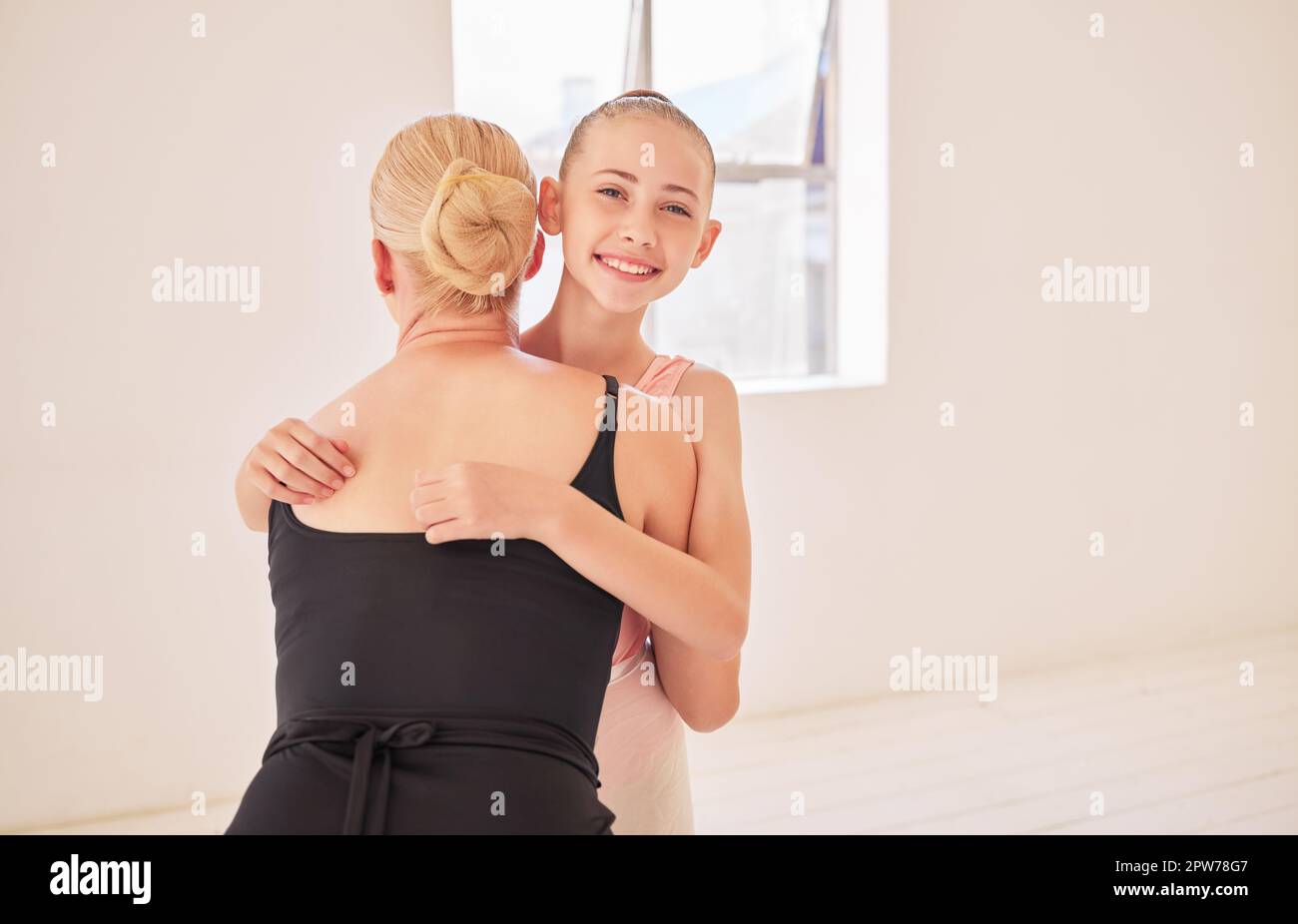 Ballet teacher giving happy student hug at dance studio, girl learning ...