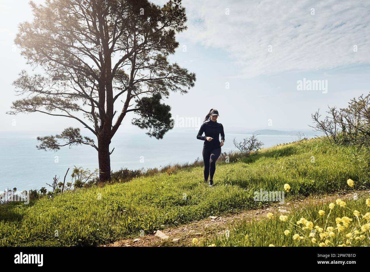 Getting to the top of the hill. a determined young woman running up a ...