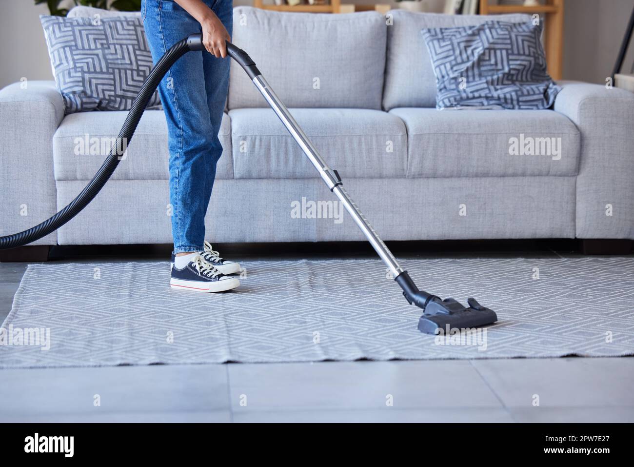 woman, vaccum and cleaning living room floor or carpet for home hygiene ...