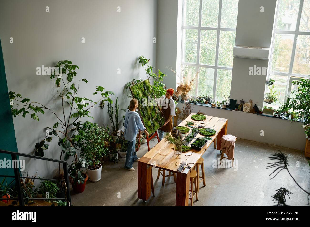 Floral design studio view with florists making decorations and ...