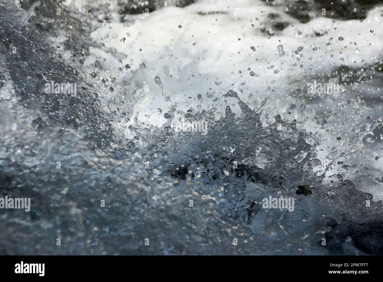 Clear, fresh stream of water splattering in a natural creek ...