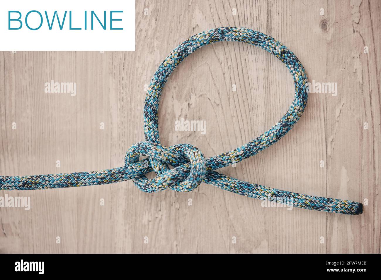 Above shot of hiking rope tied in a knot against a wooden background in ...