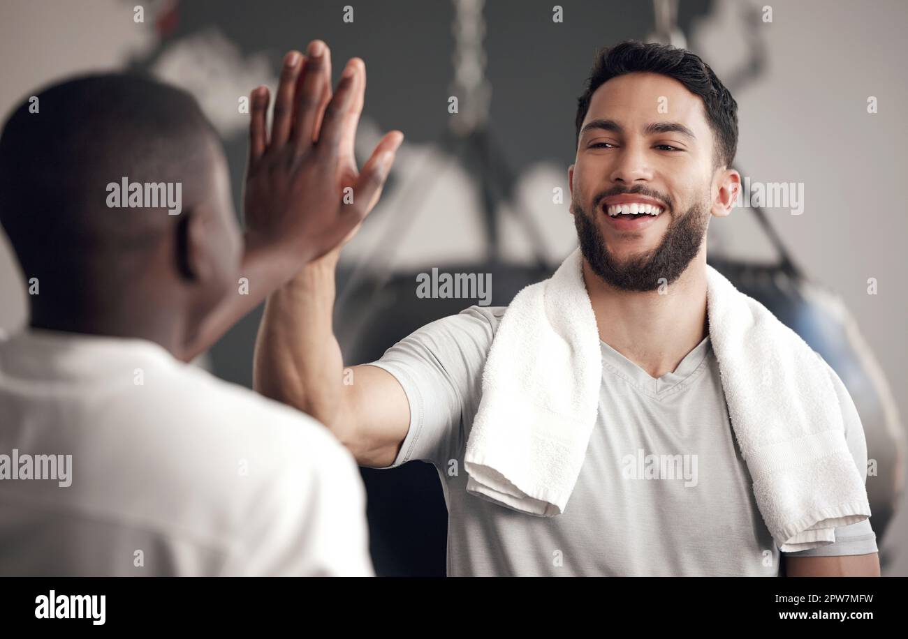 One confident young hispanic man giving a high five to his friend while ...