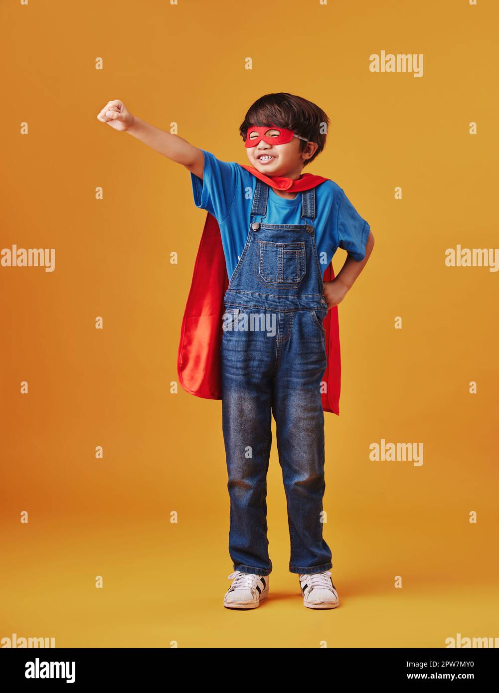 Adorable little asian boy wearing a mask and a cape while pretending to ...