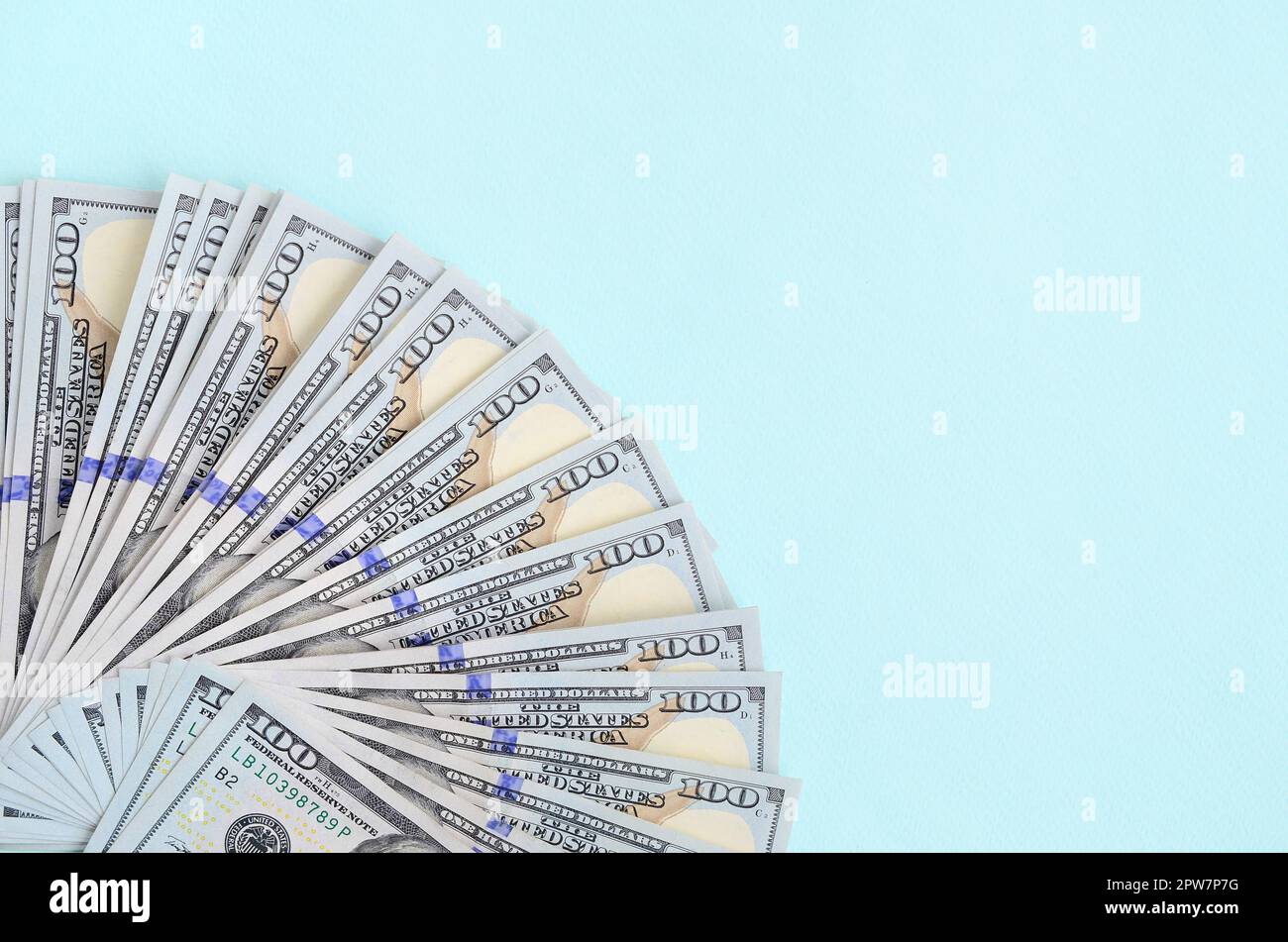 Fan of a US dollar bills of a new design lies on a light blue ...
