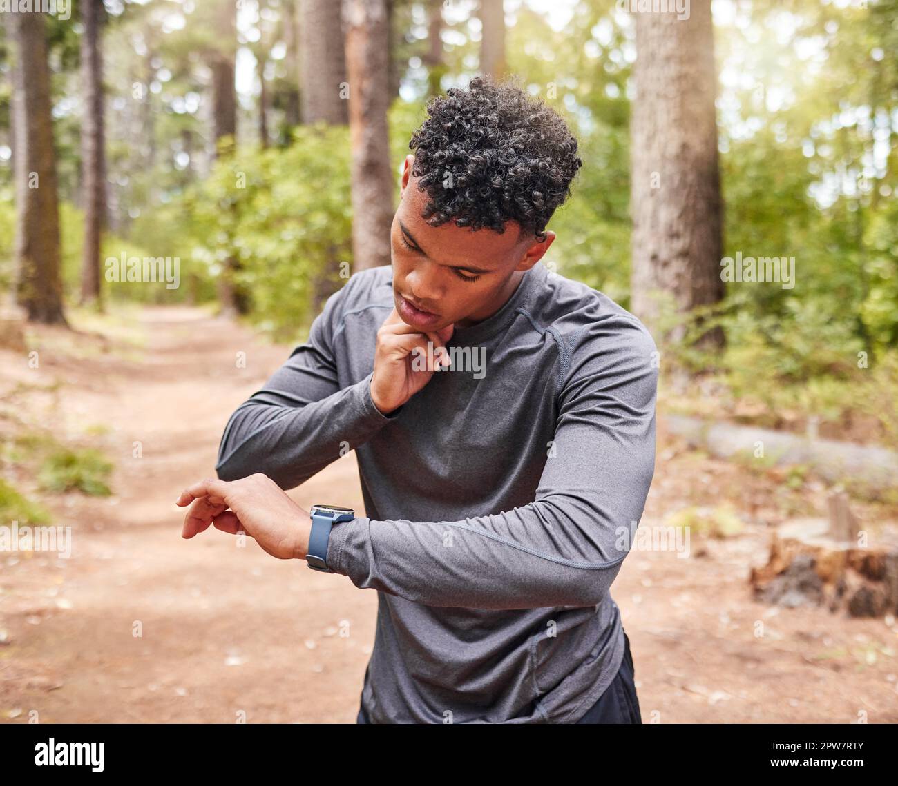 African American man checking his pulse while wearing a smartwatch and ...
