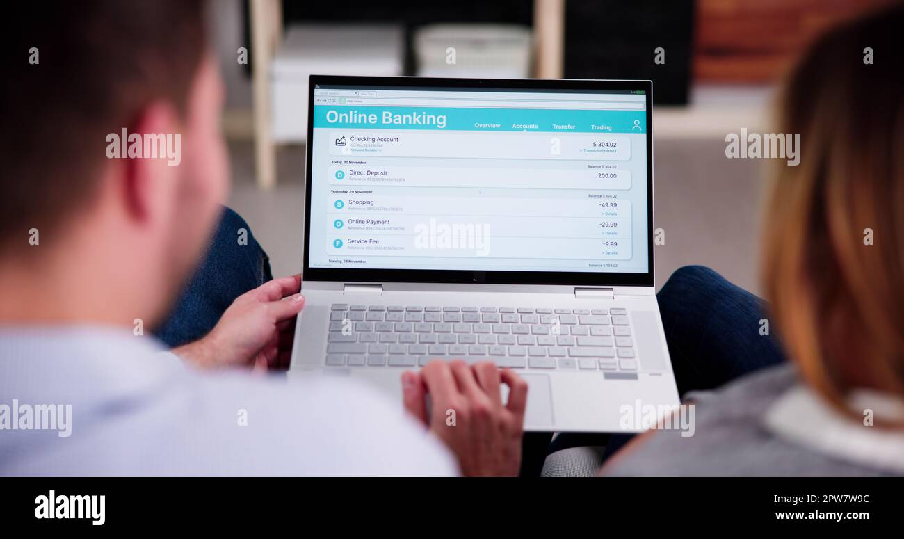 Couple Checking Bank Account Online On Couch Stock Photo - Alamy