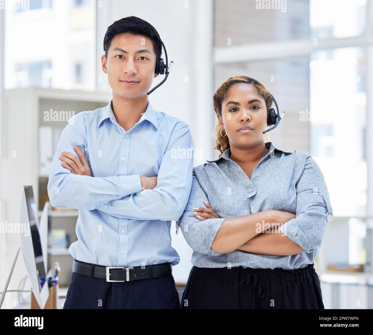 Portrait of call center colleagues. Business People working in customer service wearing headsets ...