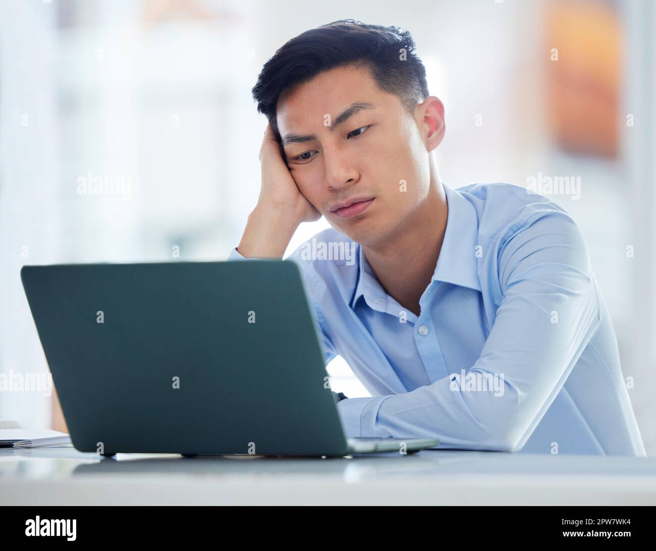 One young asian business man looking bored, tired and demotivated while ...