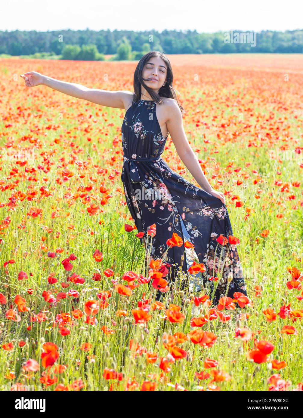 pretty young woman enjoying sun in poppy field Stock Photo - Alamy
