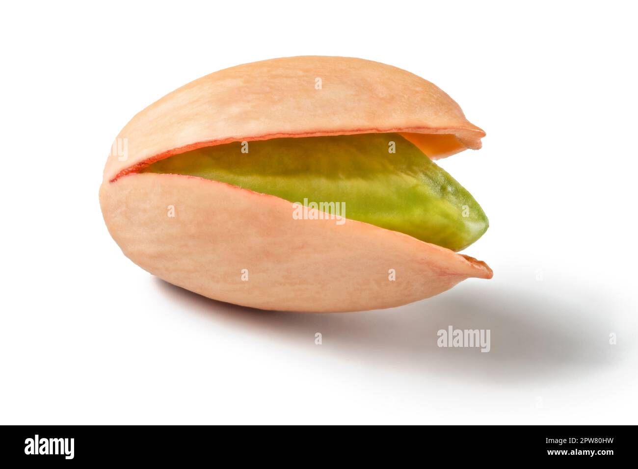 Single Turkish red pistachio, peeled green nut visible, isolated on ...