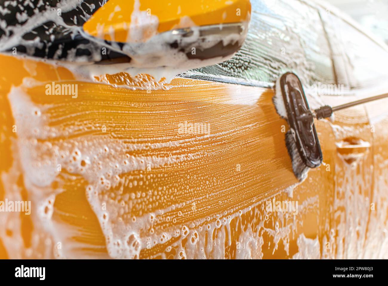 Side of car washed in self serve carwash, strokes from brush in white ...