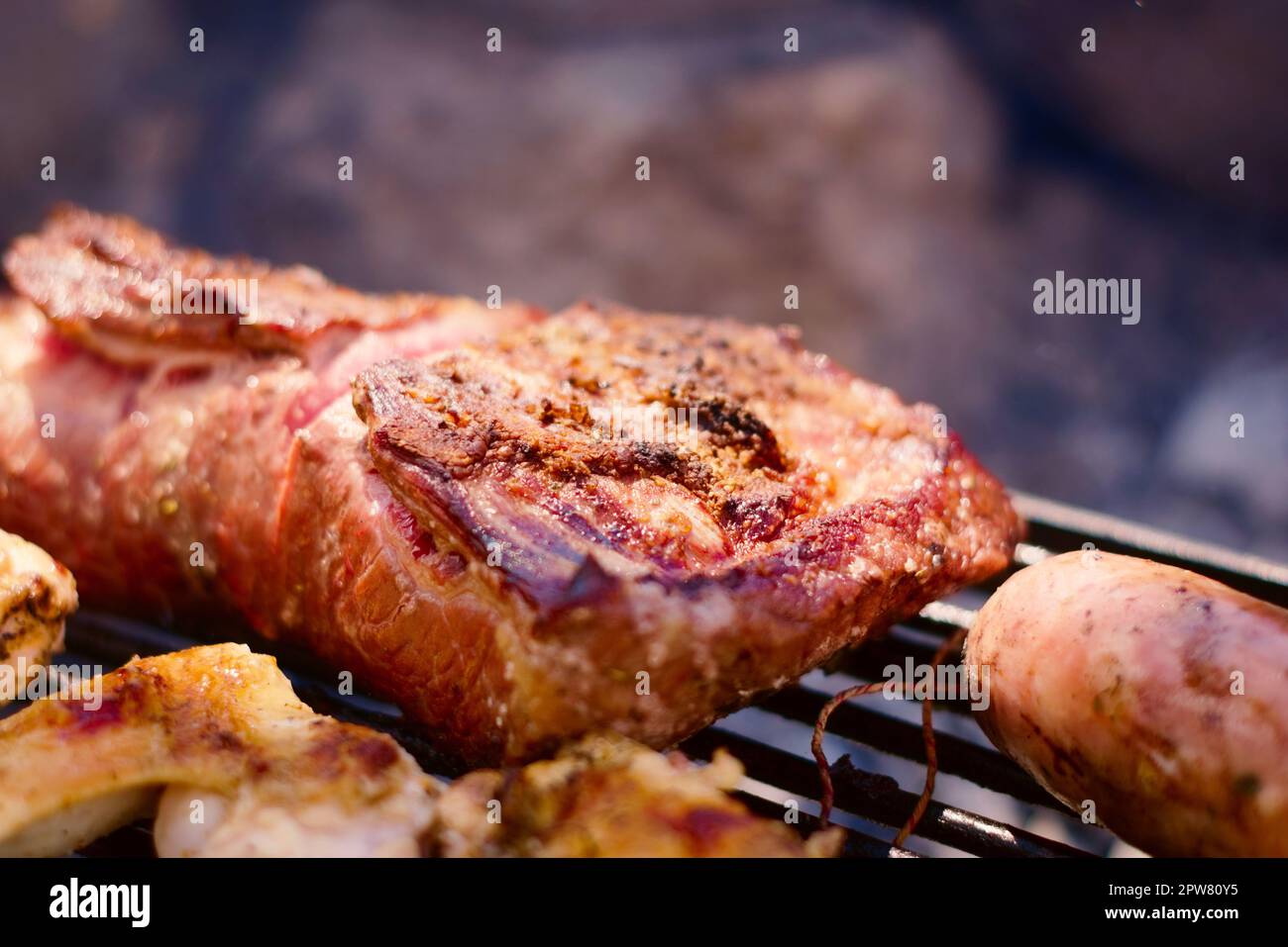 Argentinian asado. Juicy red meat and chicken wings getting roasted ...