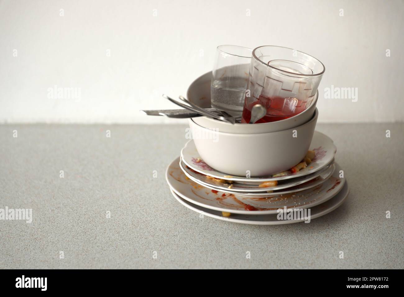 Stack of dirty dishes with food leftovers on the table after meal ...