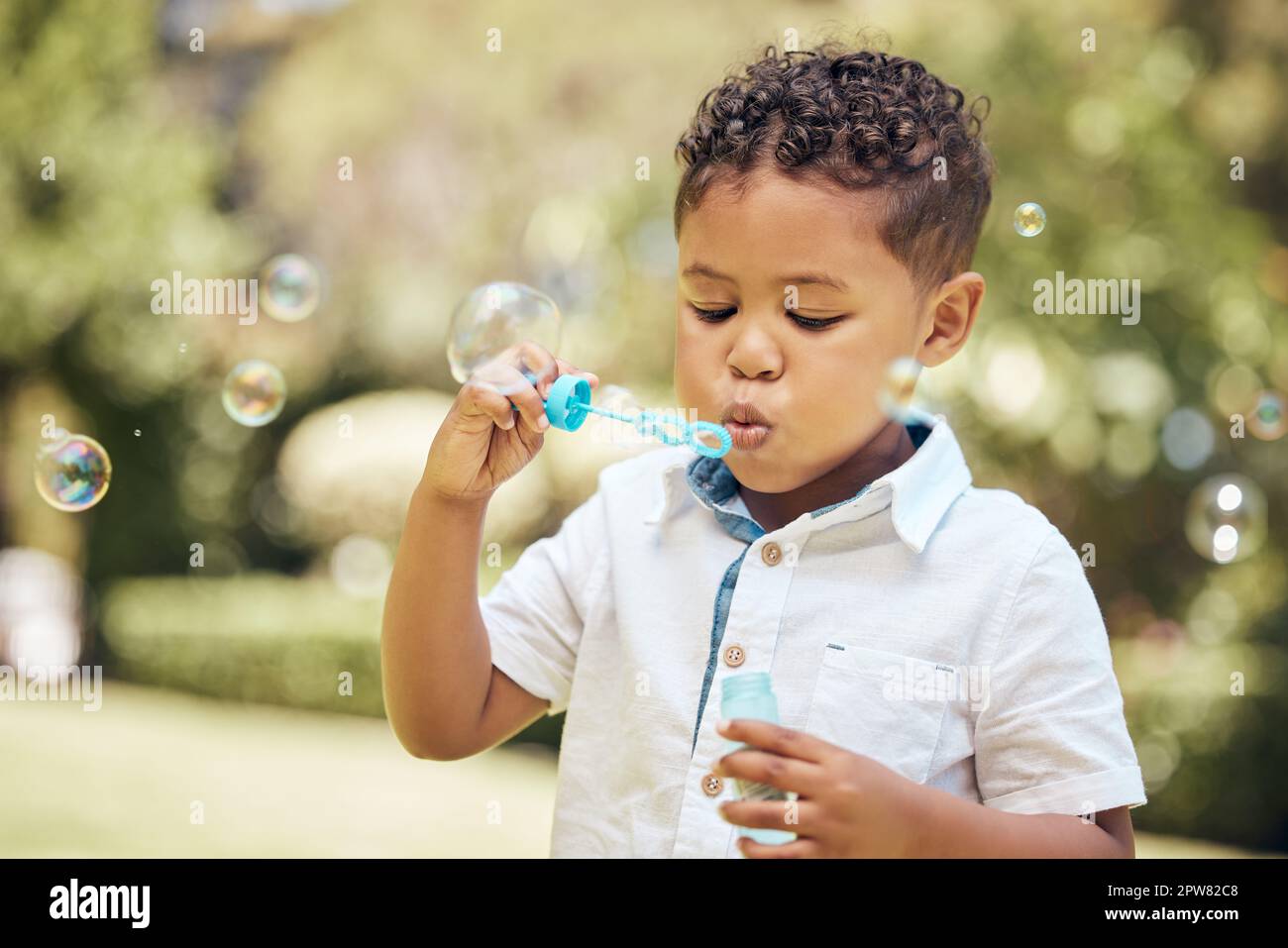 shot of a little boy blowing bubbles in a garden at home Stock Photo - Alamy
