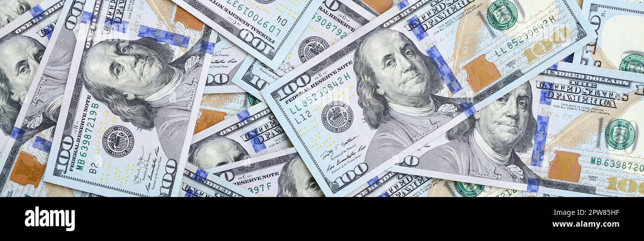 A large number of US dollar bills of a new design with a blue stripe in ...