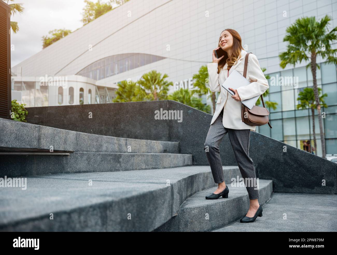 Stepping going up stairs in city, Business woman hold laptop computer ...