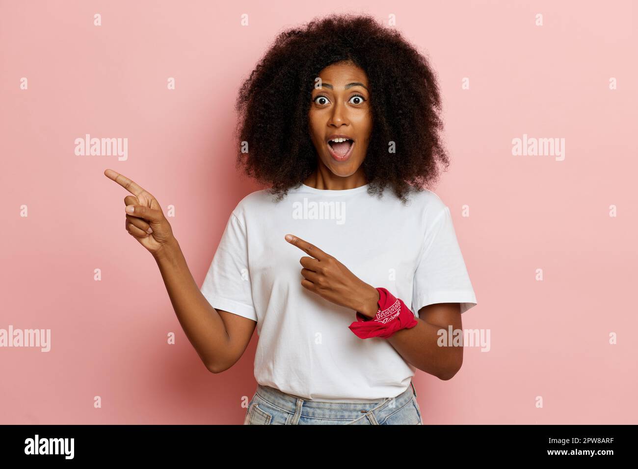 Cute dark skinned woman with happy facial expression pointing a side ...