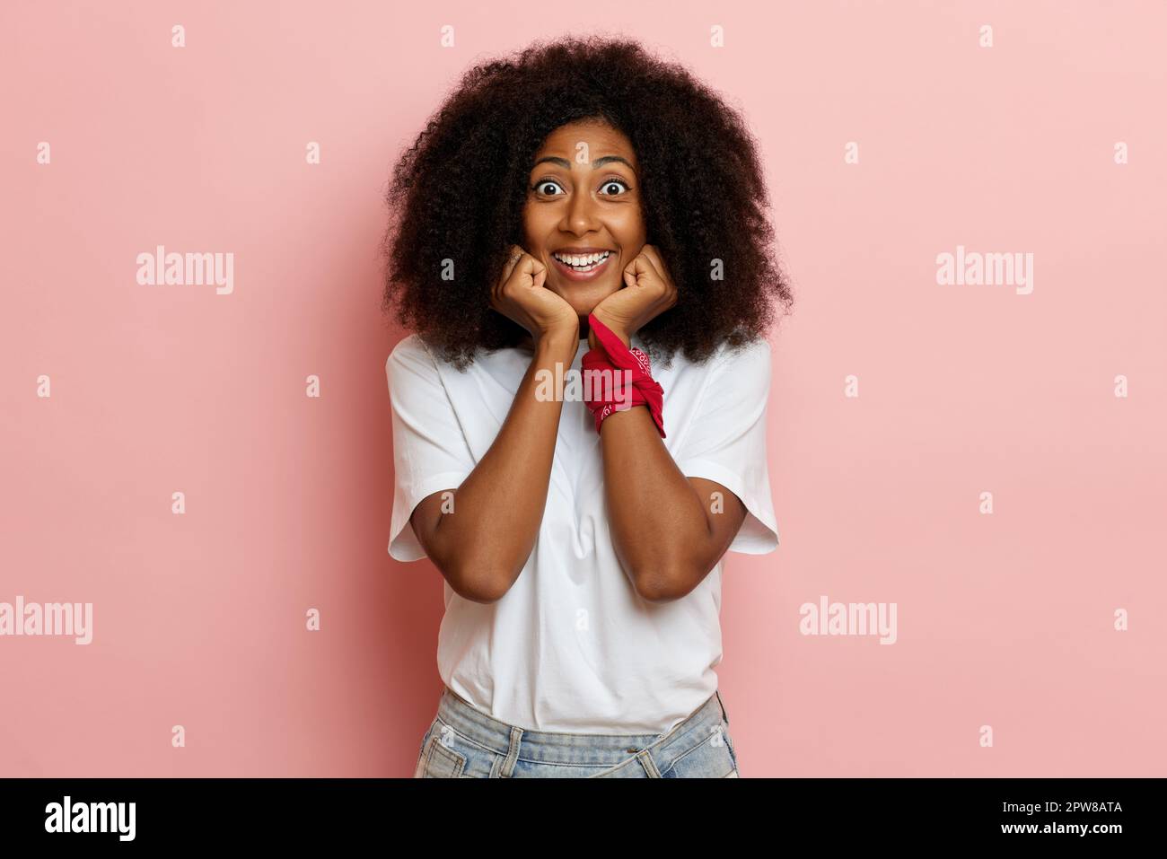 Happy African American woman, keeps hands under chin and smile. High ...
