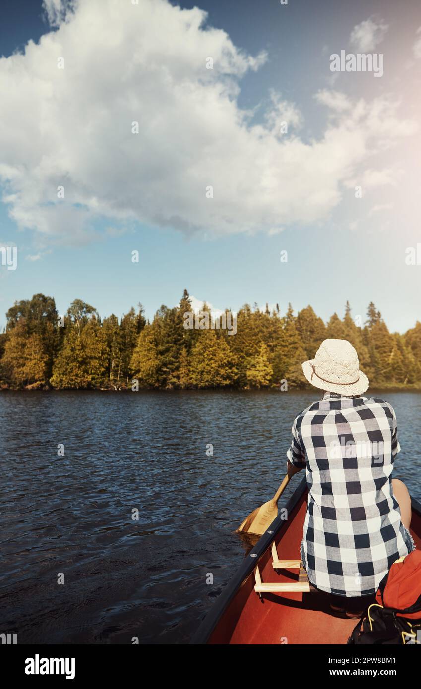 Floating in nature. an attractive young woman spending a day kayaking ...