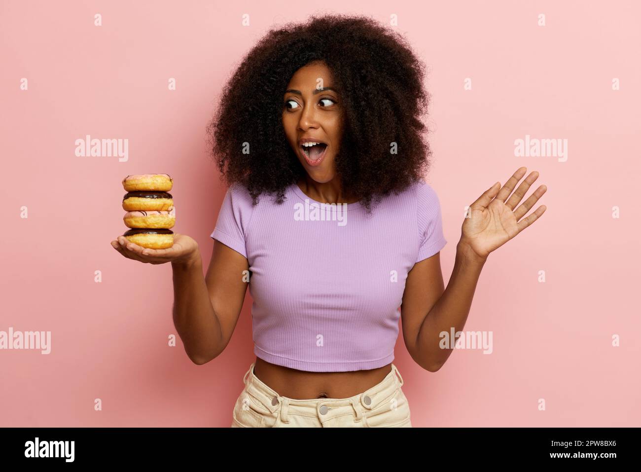 Portrait shot of surprised dark skinned young woman with overjoyed ...