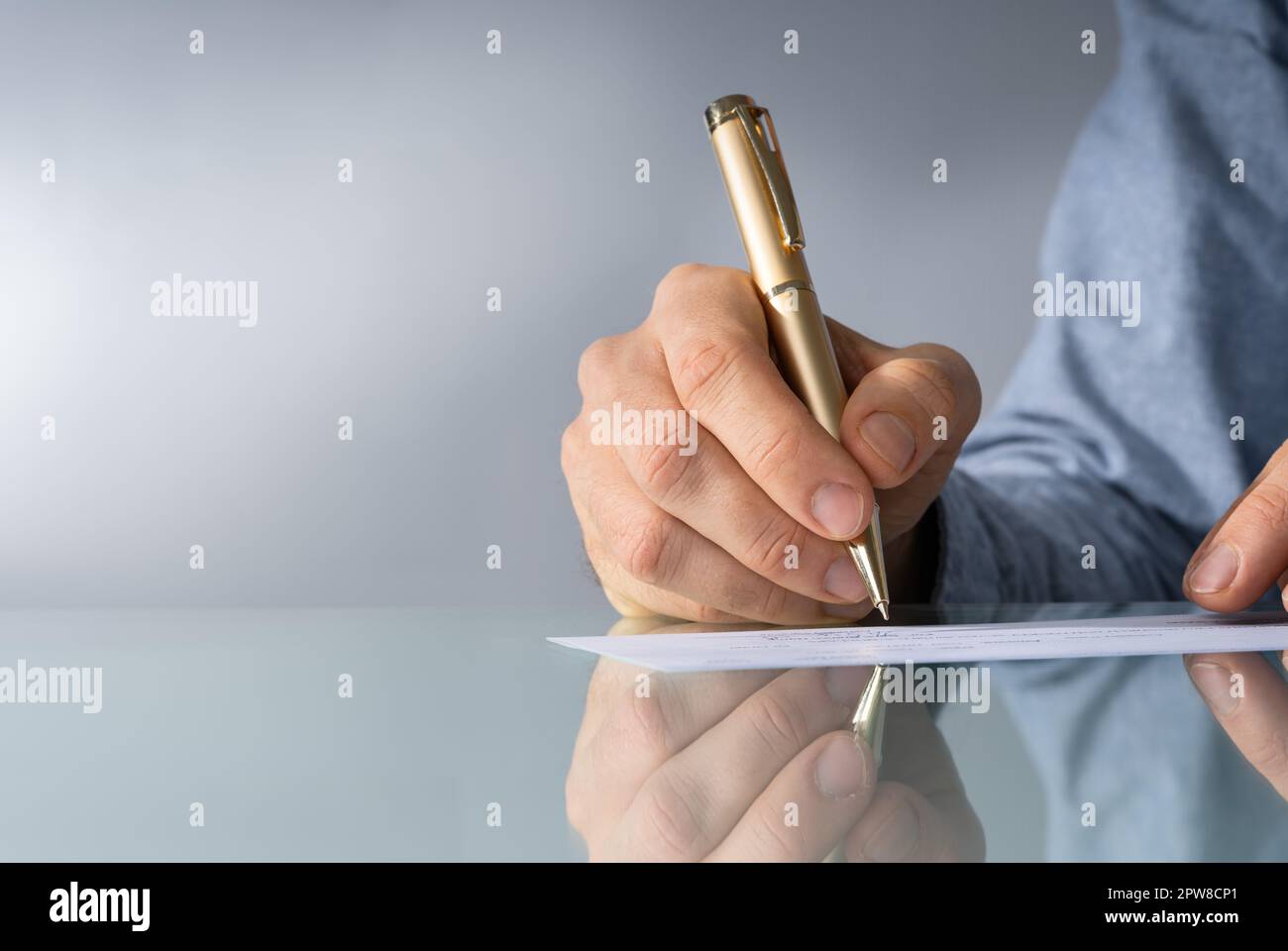 A Male Hand Filling Out The Amount On A Cheque Stock Photo - Alamy