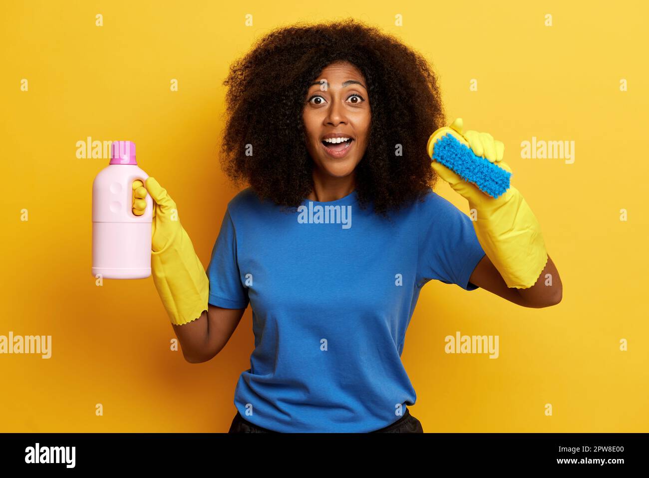 Happy curly haired dark skinned housekeeper woman,, smiles and holds a ...