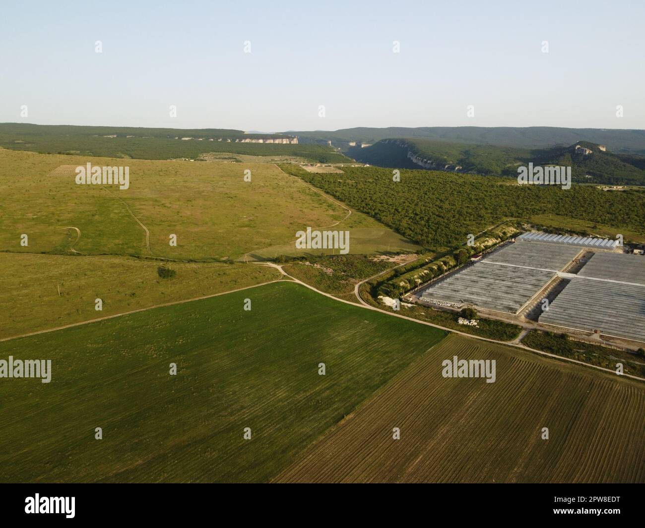 Aerial view on greenhouse factory surrounded by wheat field in ...
