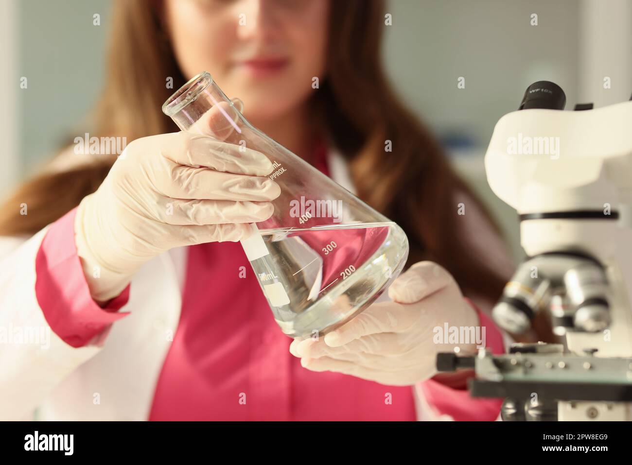 Female student holds glass flask with clean water in hands Stock Photo ...