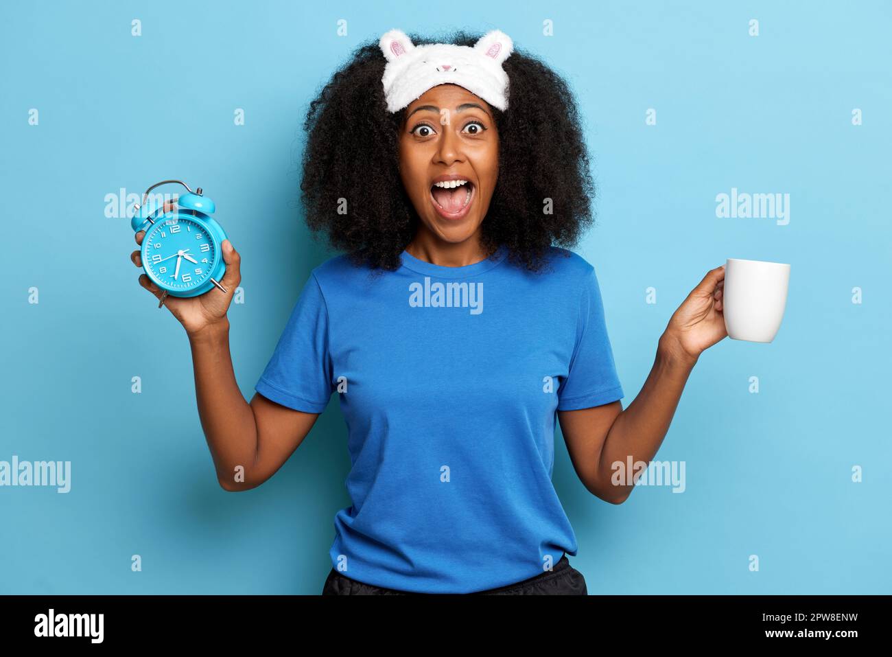 African American woman screaming with clock alarm and coffee in the ...