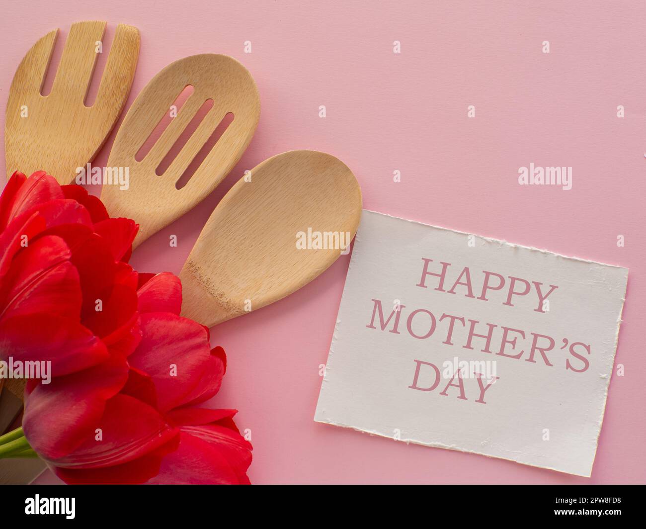 Red tulips flowers with kitchen tools on pink background with white ...