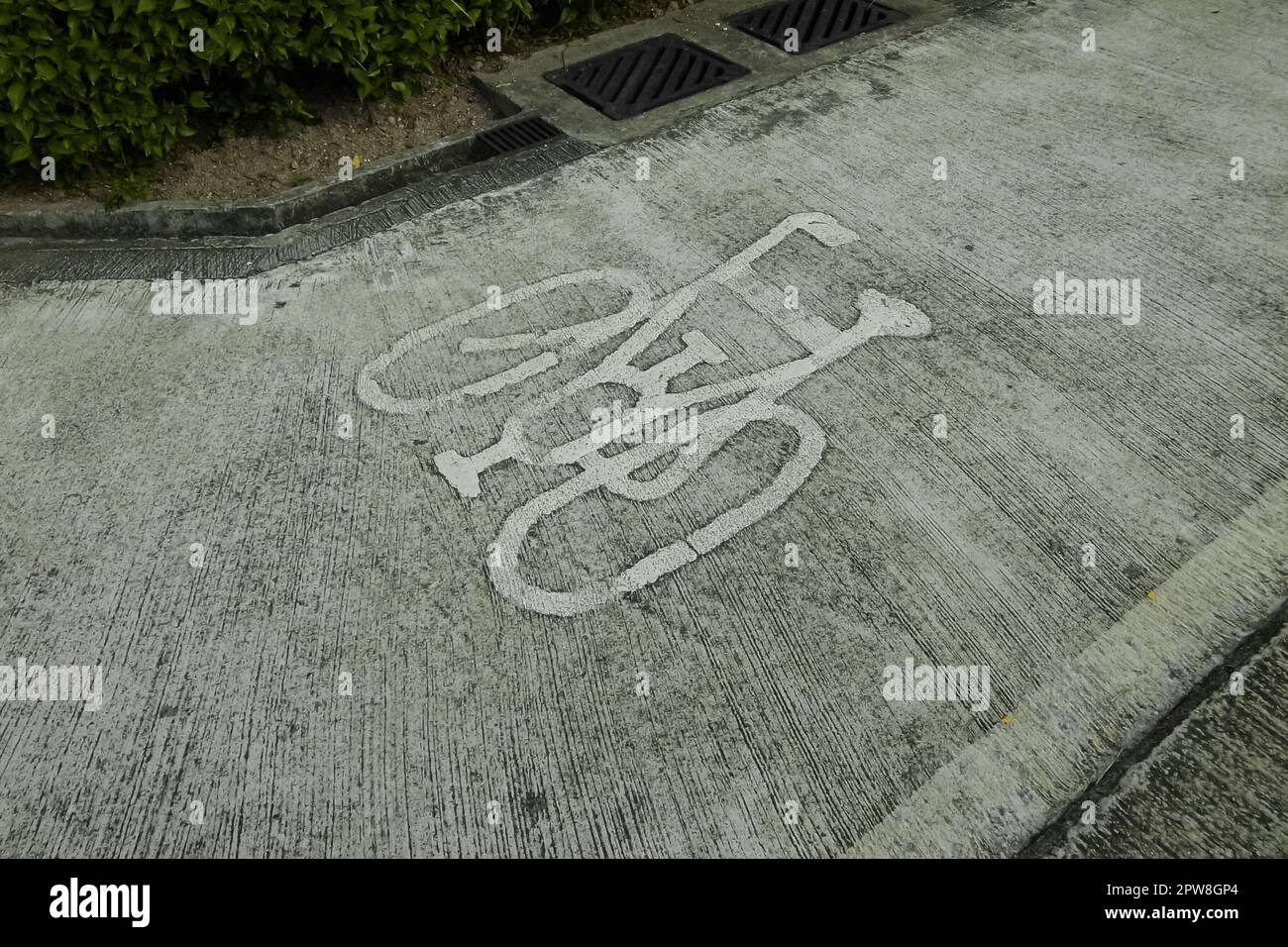 The close-up of white painted bicycle sign on road. Bike Lane Markings ...