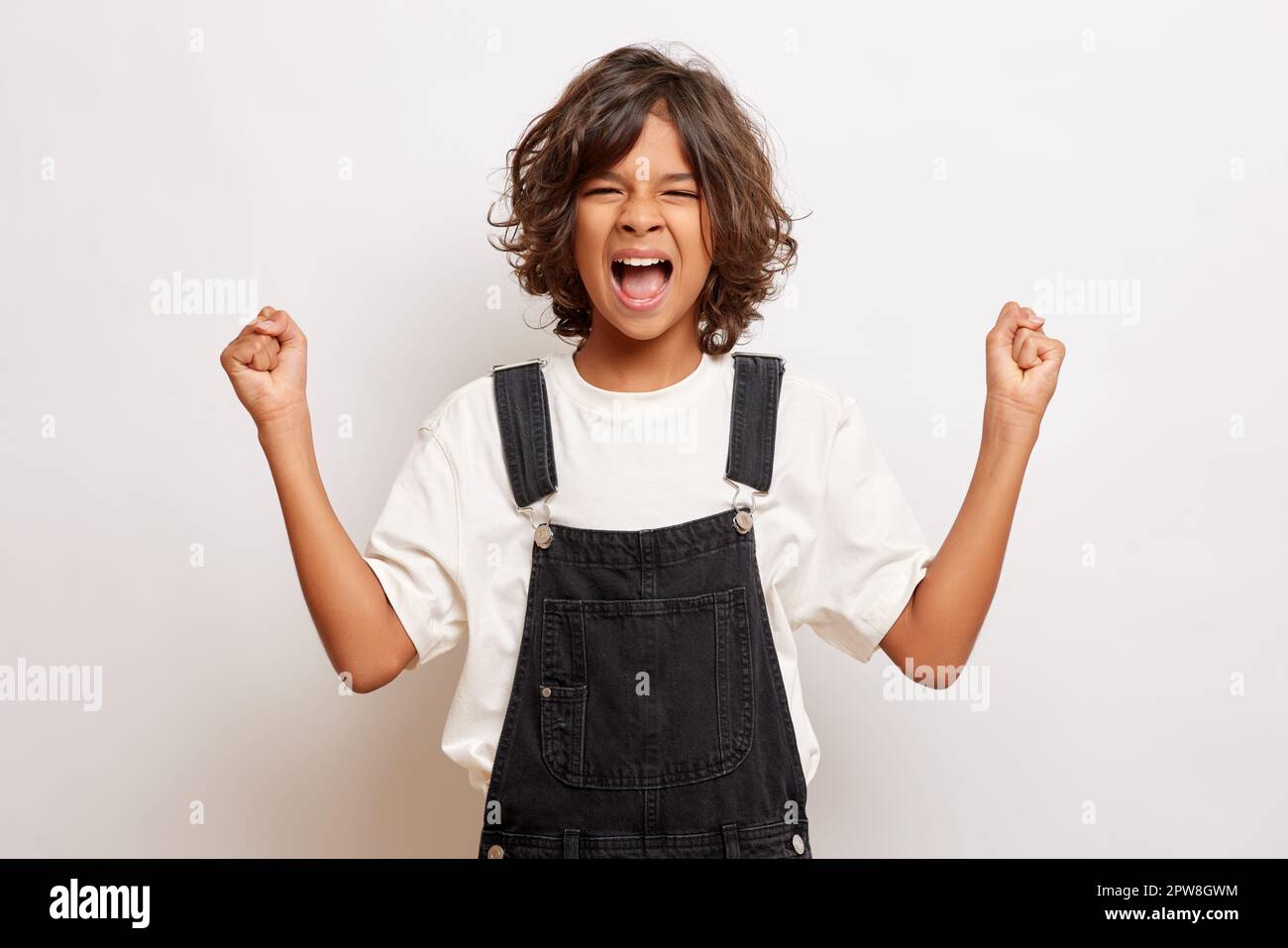 Positive cheerful young guy with curly hairstyle makes yes gesture ...