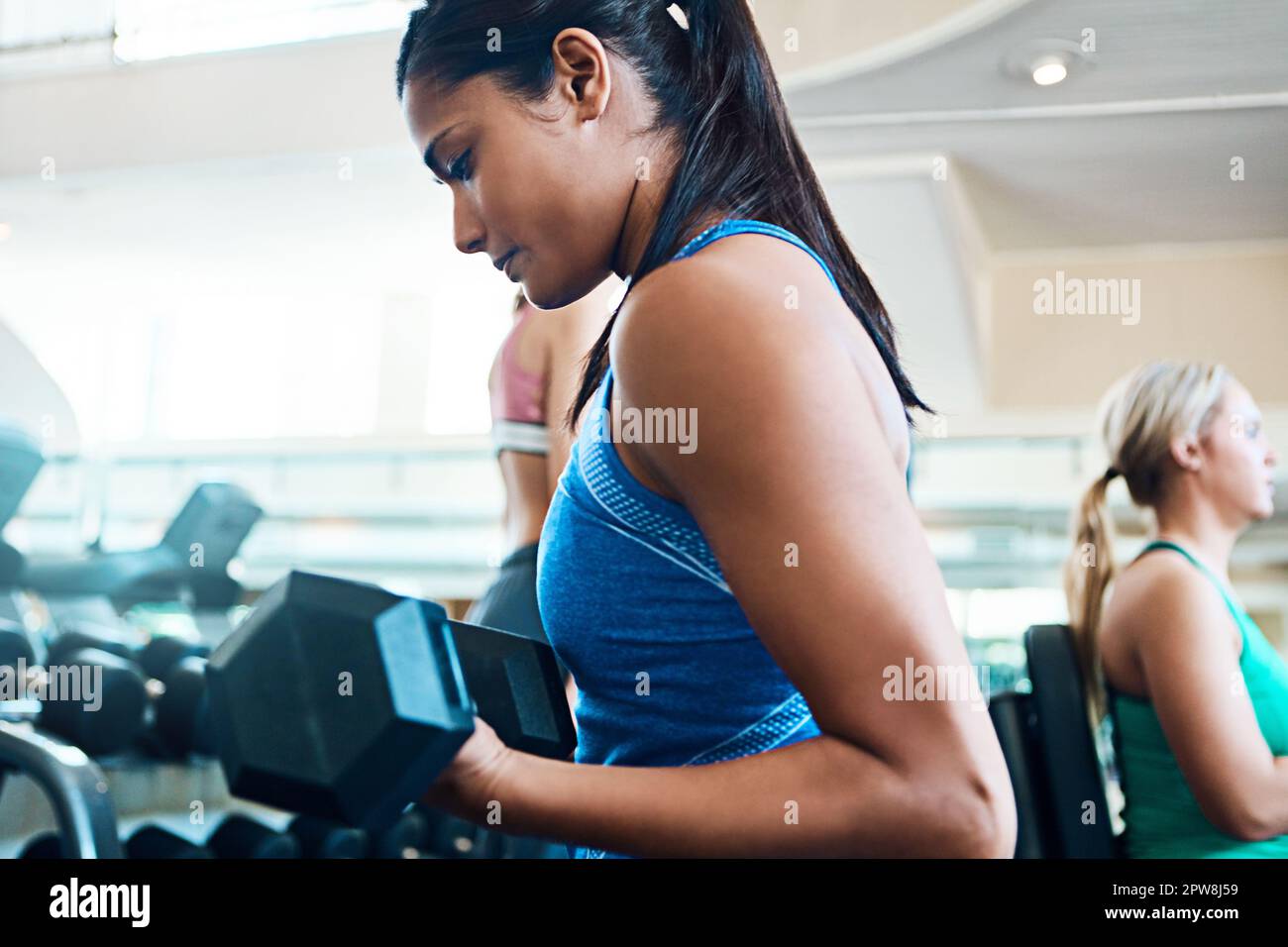 Shes got the power. attractive young women working out with dumbbells ...