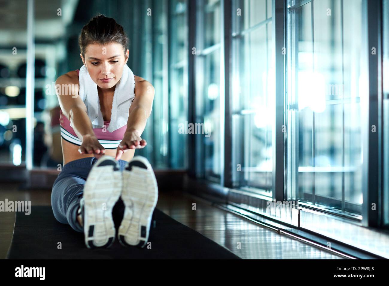 Getting in a good pre-workout stretch. an attractive young woman going ...