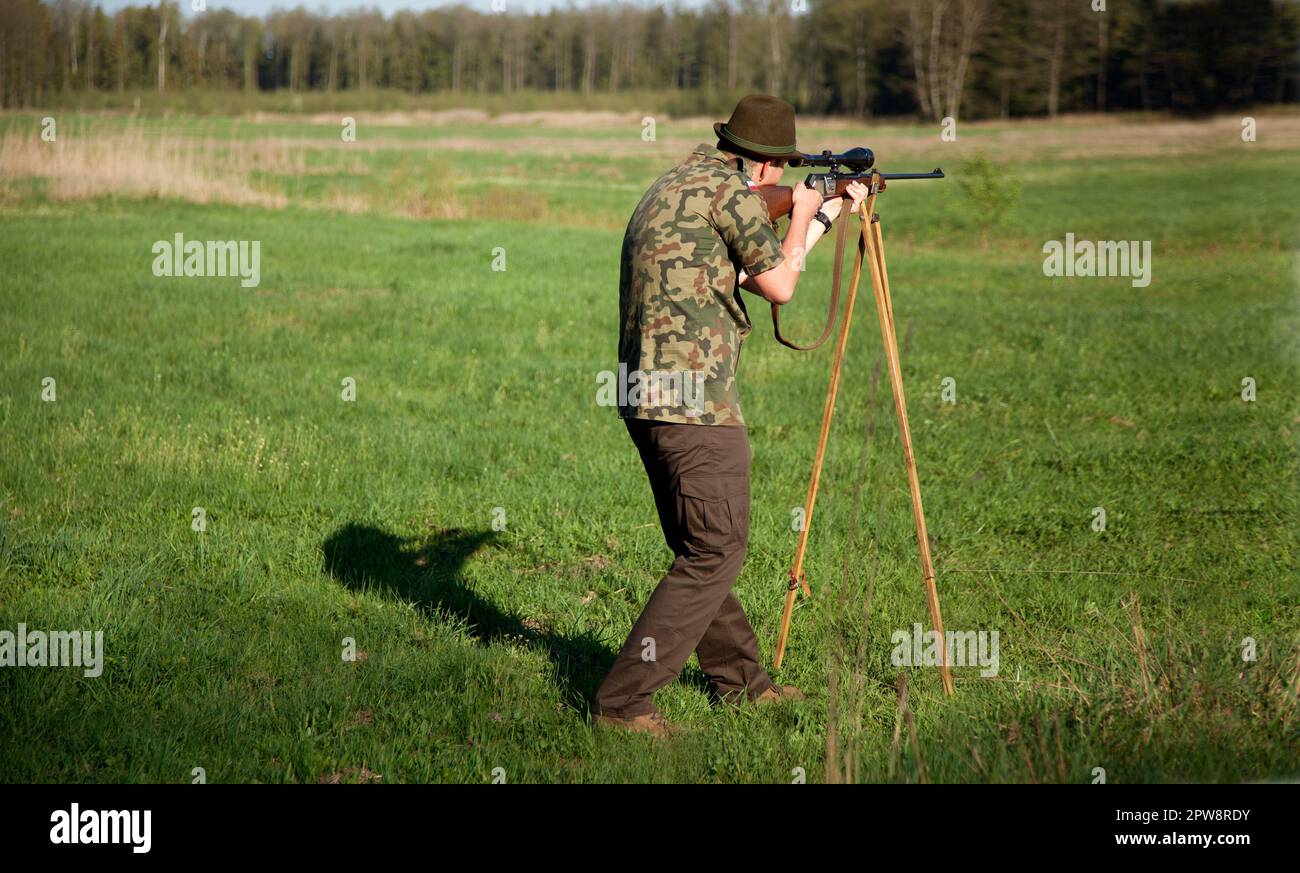 Hunter, gun and man in field in nature on a Africa safari for animal ...