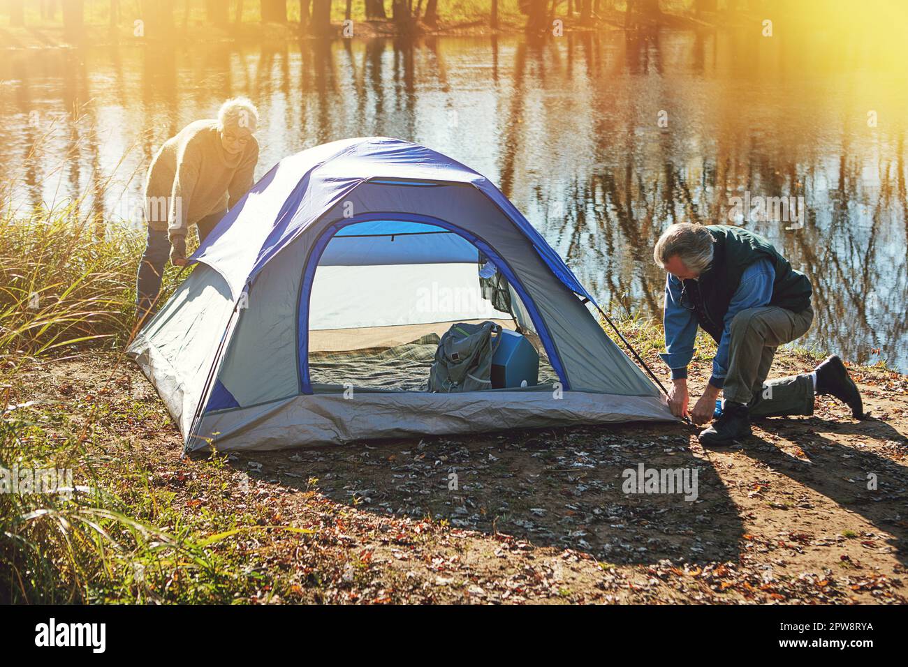 Setting up their little nest at the campsite. a senior couple setting ...