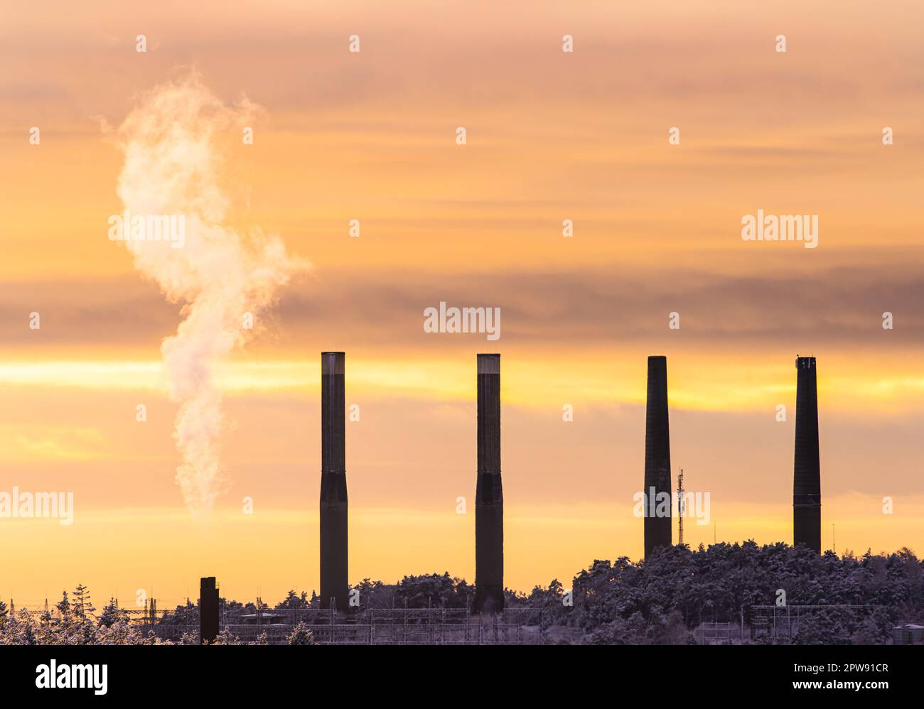 Steam rising from a funnel with four other smoke stacks in the distance ...