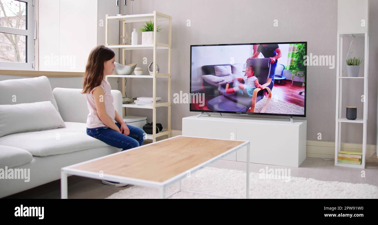 Kid With Remote Control Sitting On Couch Watching Movie On Tv Stock ...