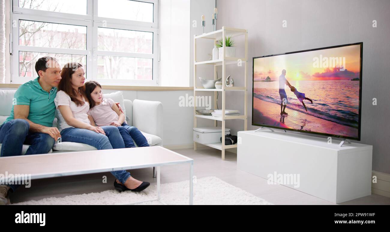 Young Family Watching TV Together At Home Stock Photo - Alamy