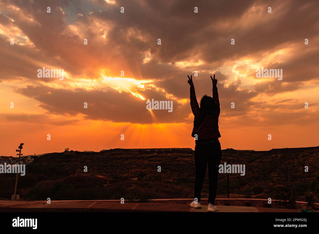 girl backlit shot with sunset dramatic sky with sun beams with dark ...