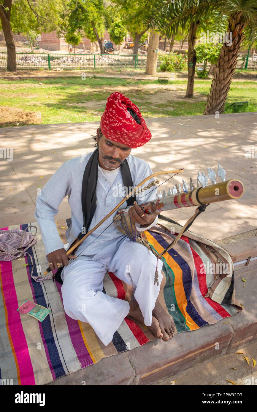 man playing traditional musical instrument in authentic local dress at ...