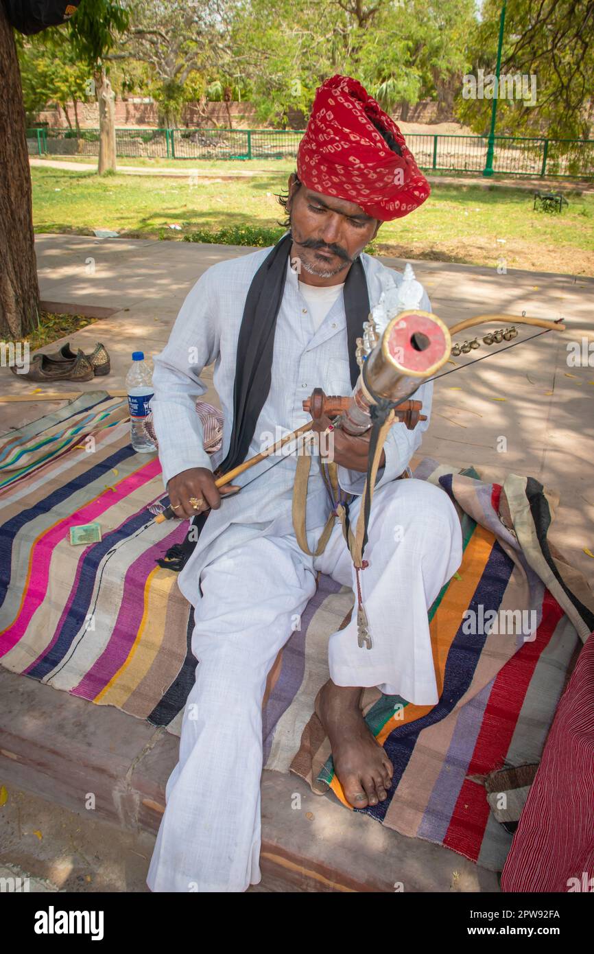 man playing traditional musical instrument in authentic local dress at ...