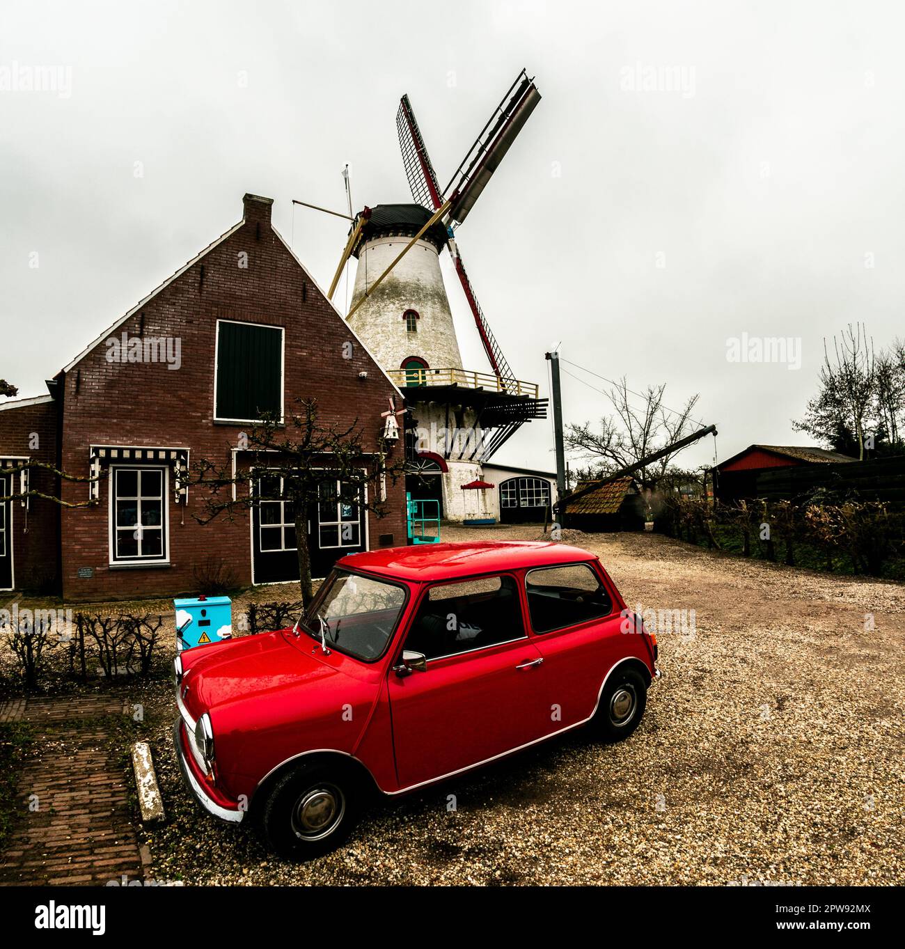 Red Mini Cooper in front of an old beautiful mill in the Netherlands ...