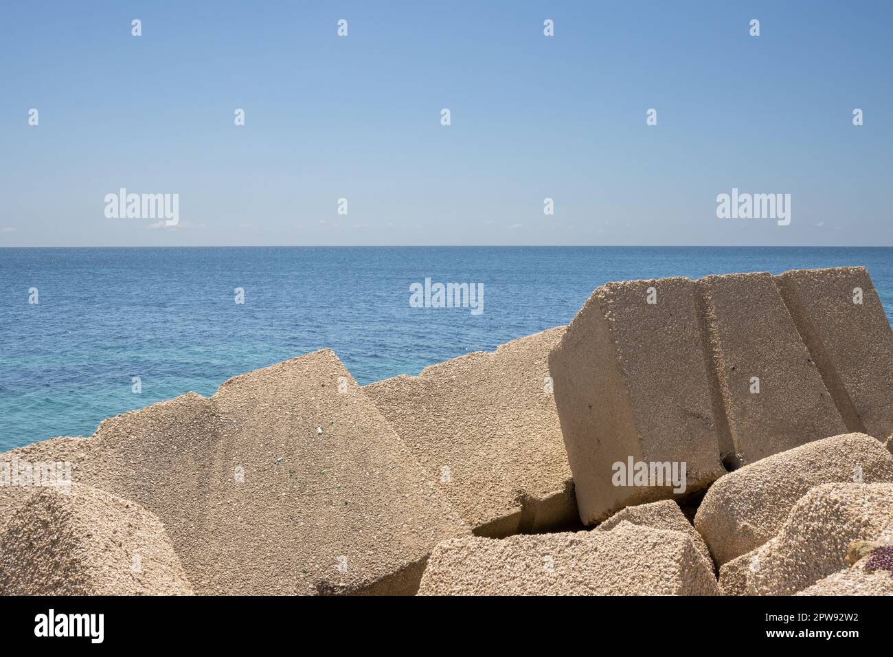 Huge cubic objects, made of concrete, used as a seawall in local marina ...
