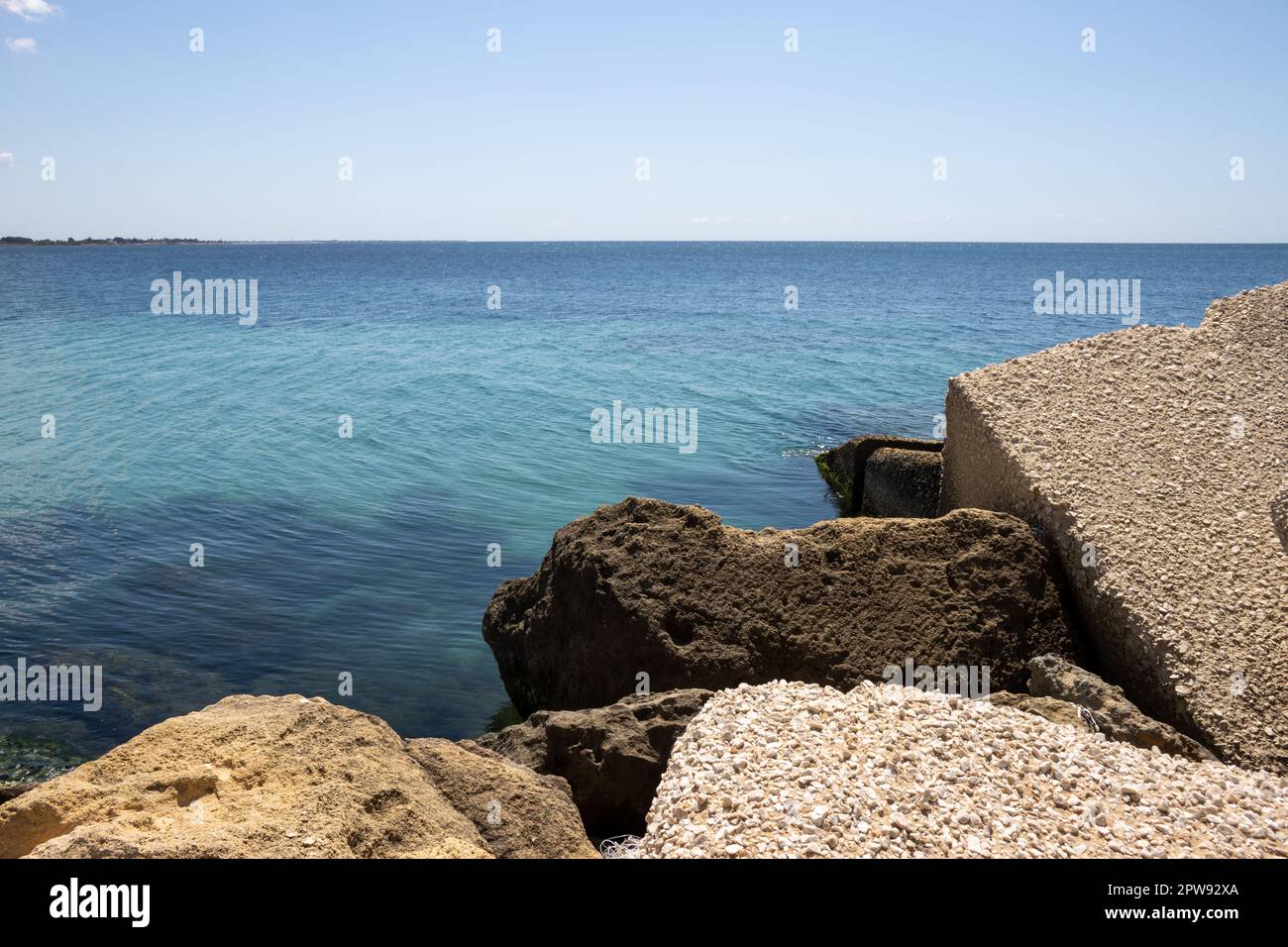 Huge cubic objects, made of concrete, used as a seawall in local marina ...