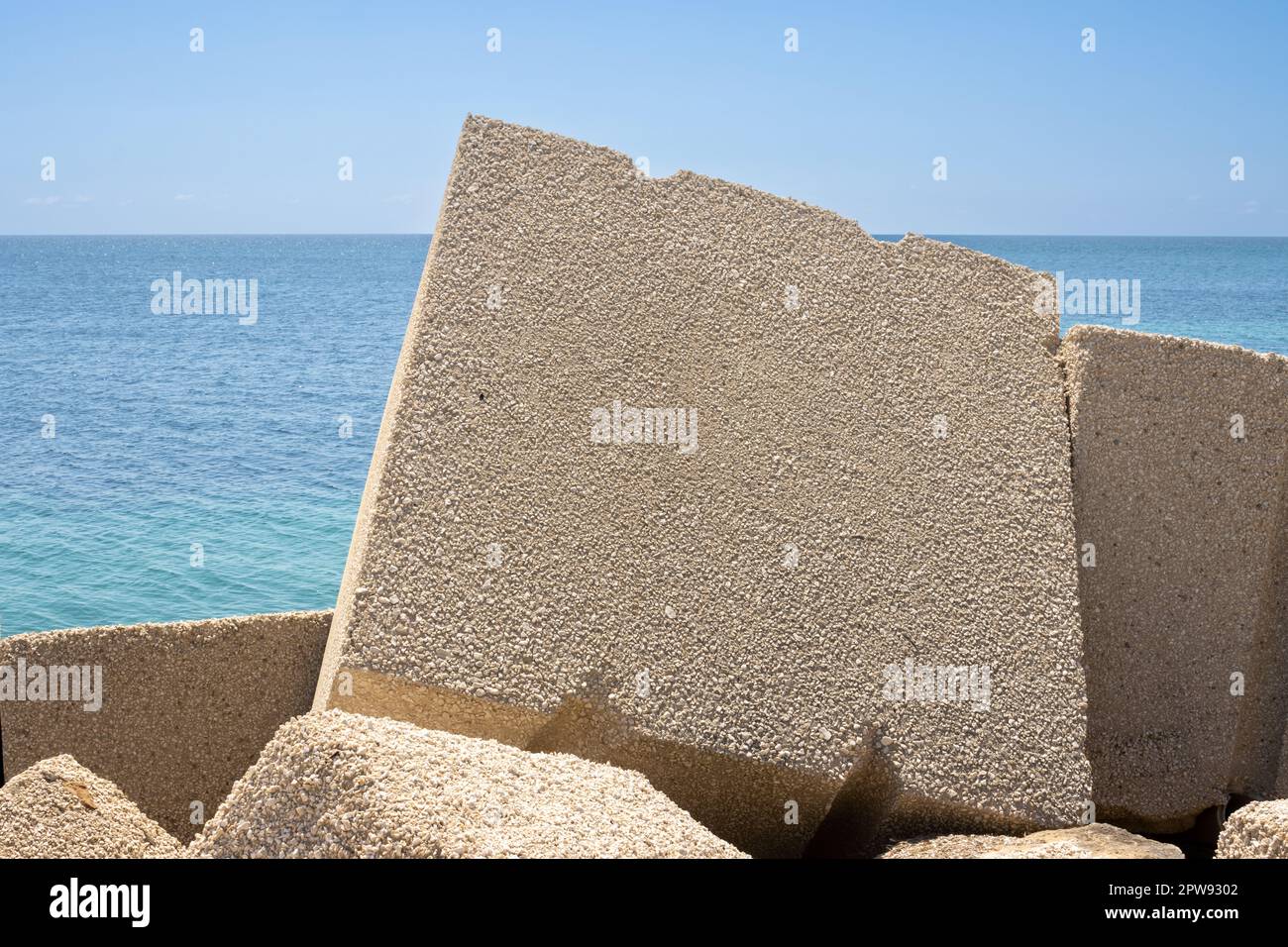 Huge cubic objects, made of concrete, used as a seawall in local marina ...