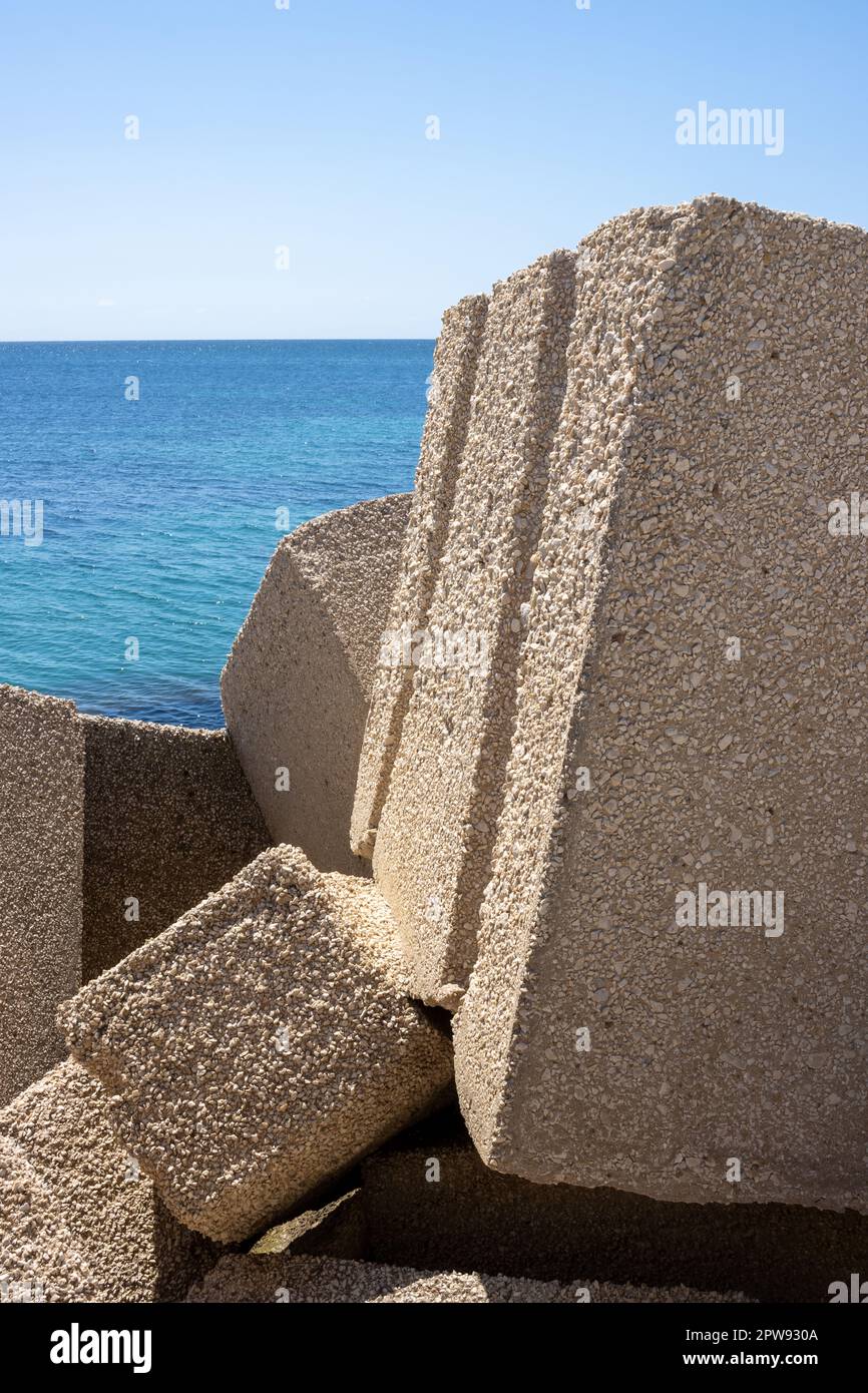 Huge cubic objects, made of concrete, used as a seawall in local marina ...