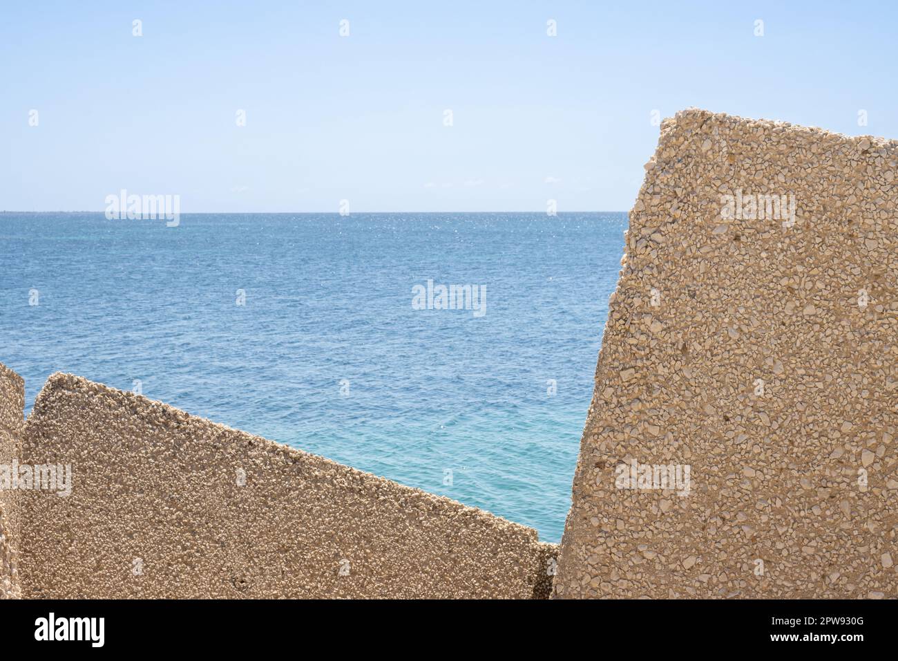 Huge cubic objects, made of concrete, used as a seawall in local marina ...