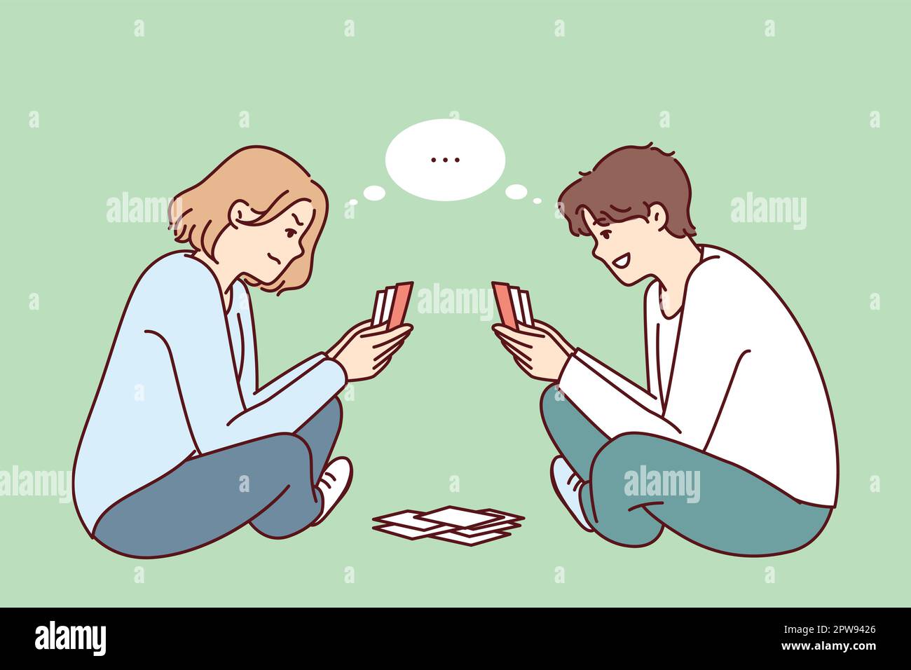 Young man and woman play cards sitting on floor and think what next ...